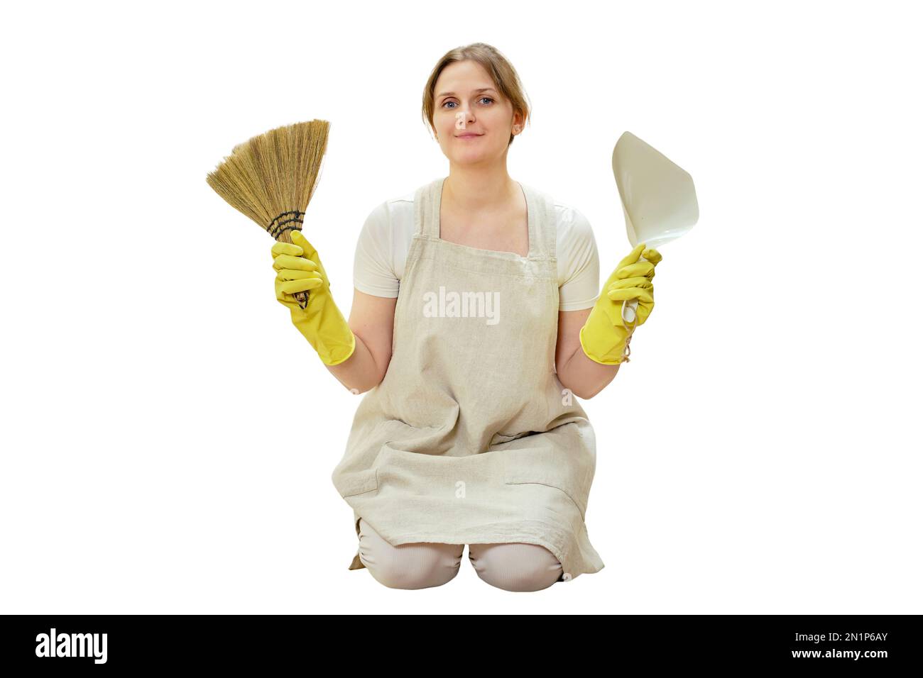 A woman sweeps the floor with a broom when cleaning the home kitchen ...