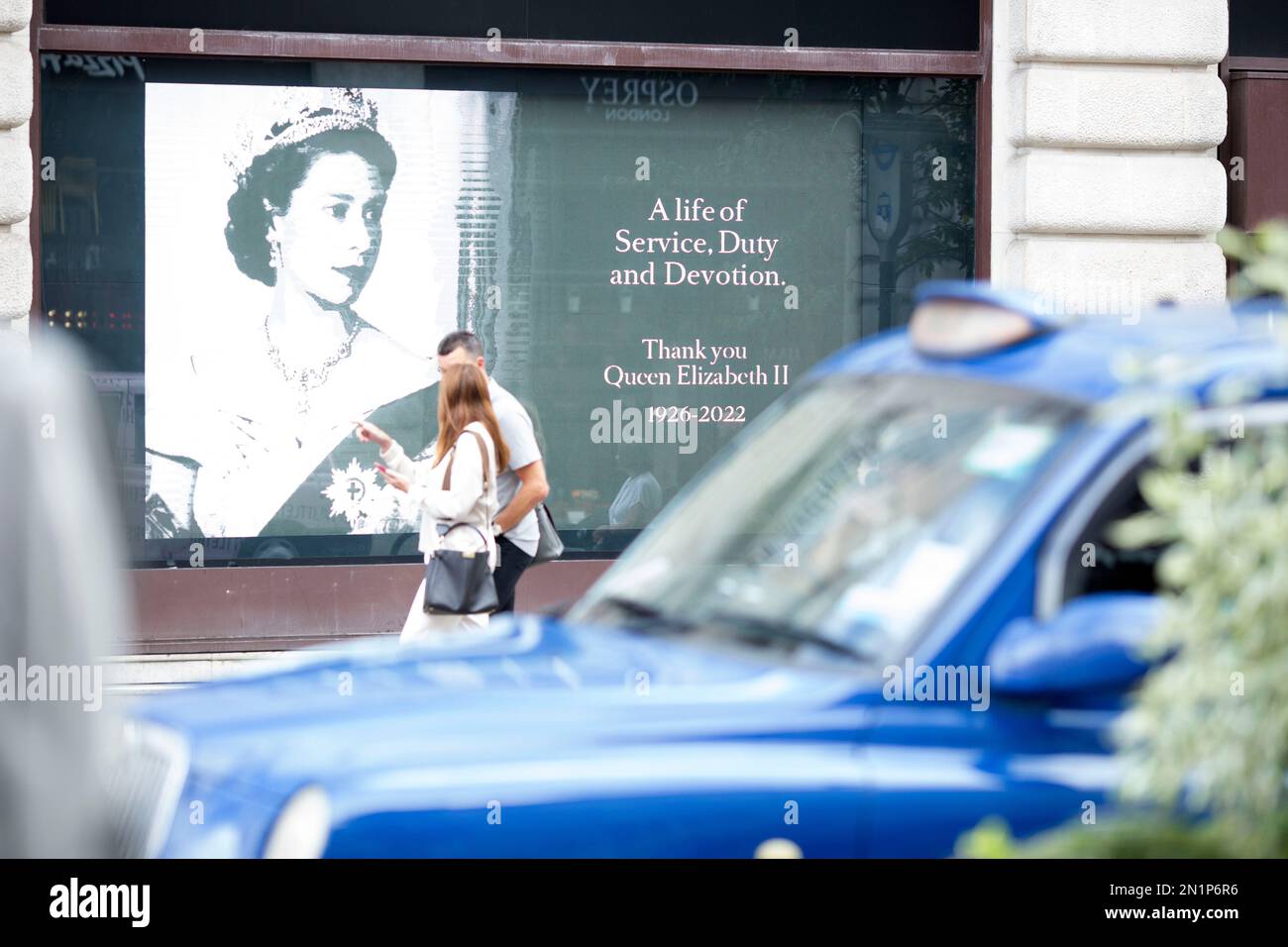 A portrait of Queen Elizabeth II is displayed in a shop window in ...