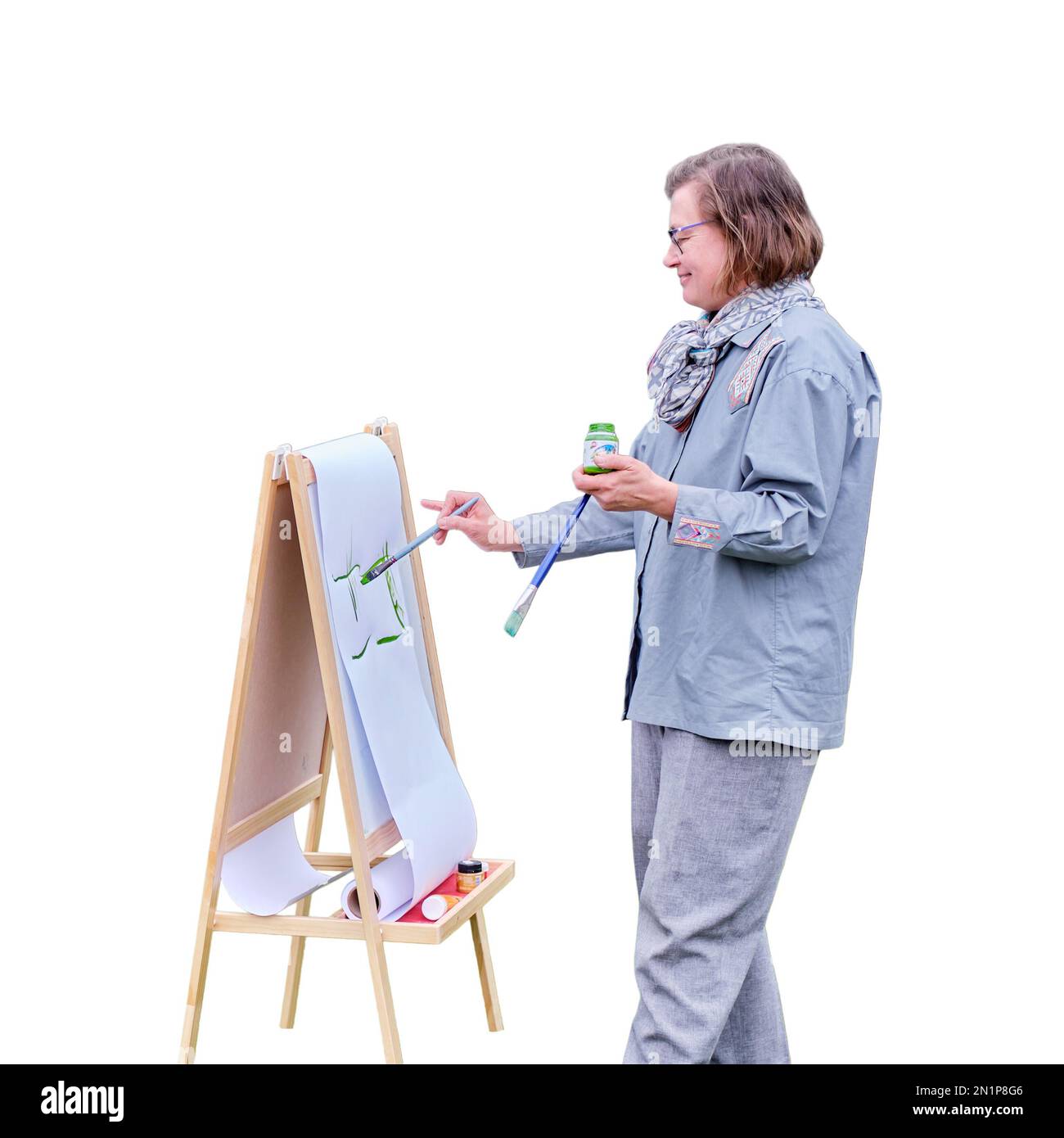 Happy woman draws on the easel with a brush and paints, isolated on a ...