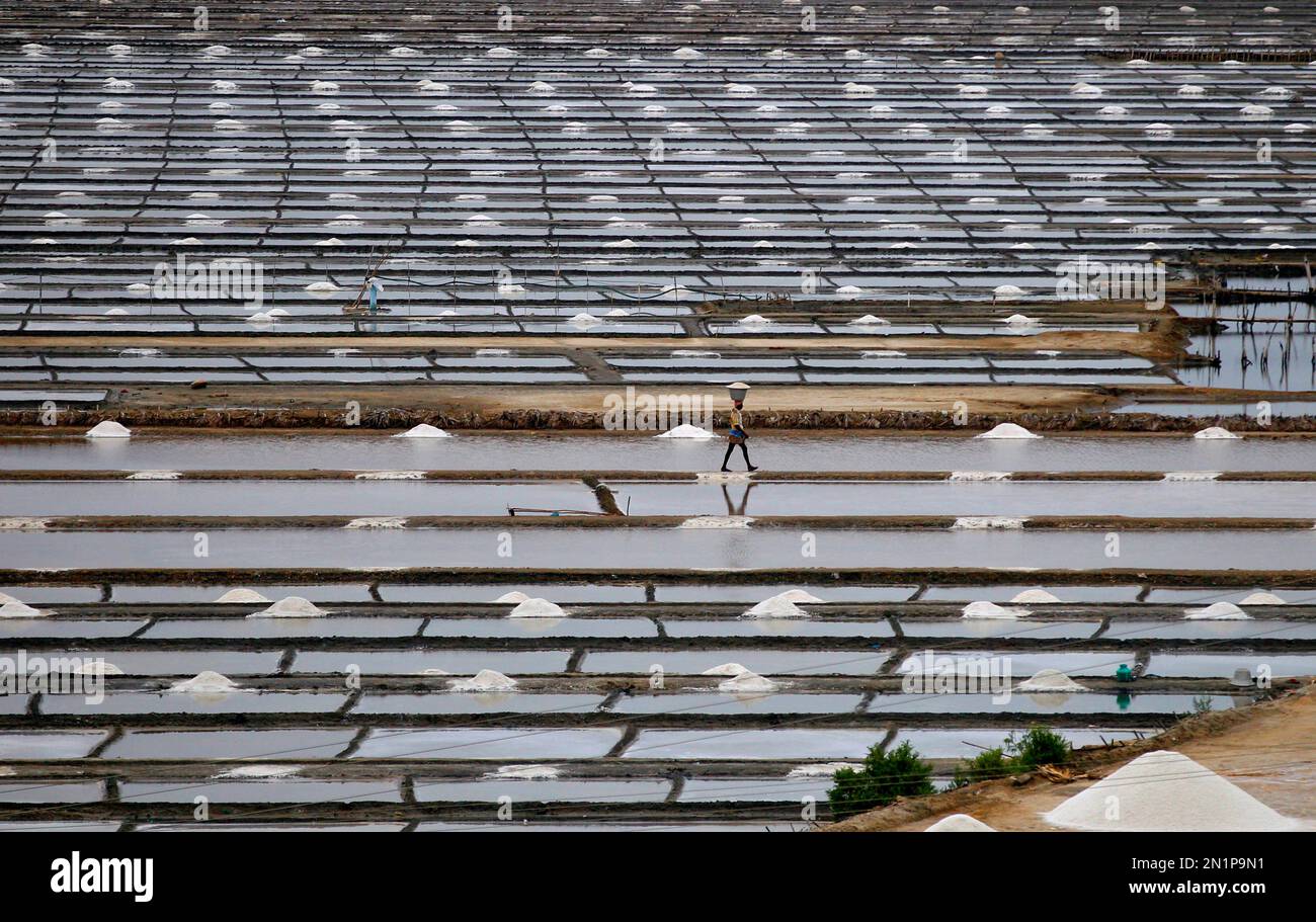 In this June 17, 2015 photo, a villager carries a bucket of salt as he ...