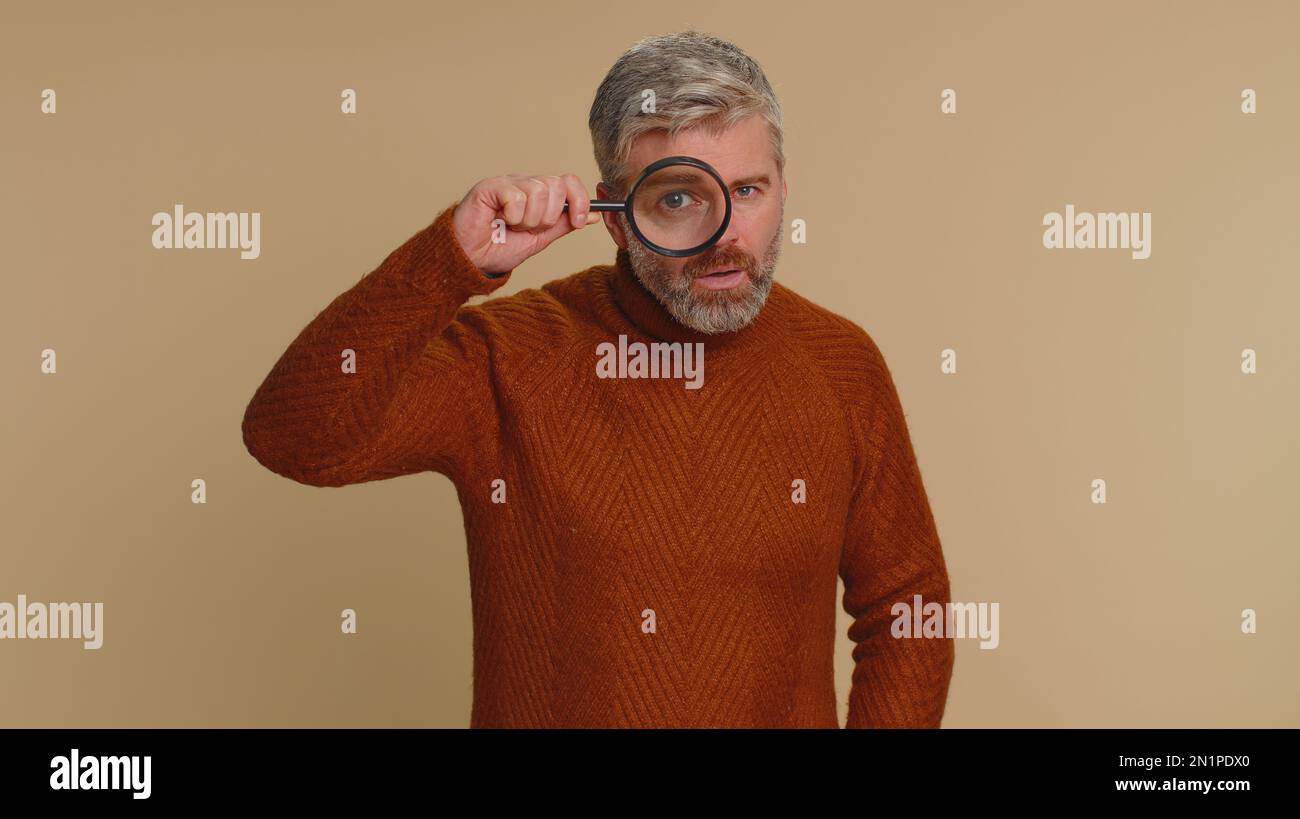 Investigator researcher scientist old man holding magnifying glass near ...