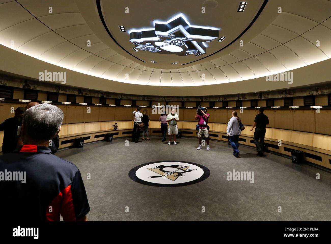 Photographers and reporters look through the locker room of the ...
