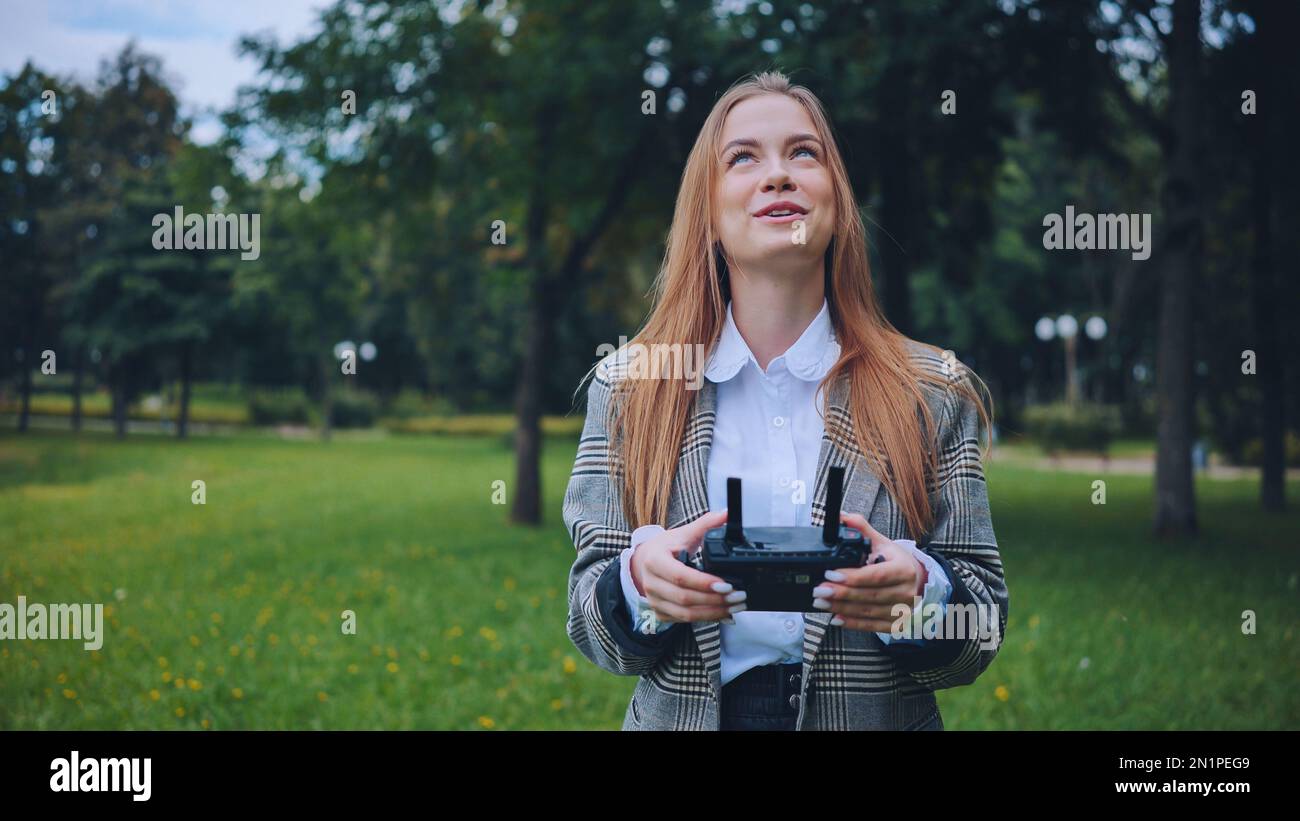 The girl controls the drone with the remote control in her hands Stock ...