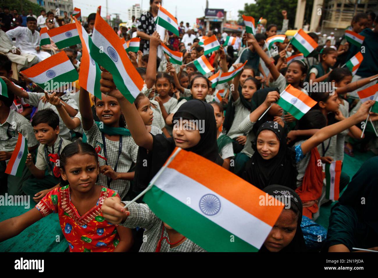 Students wave national flags during the flag hoisting ceremony at a ...