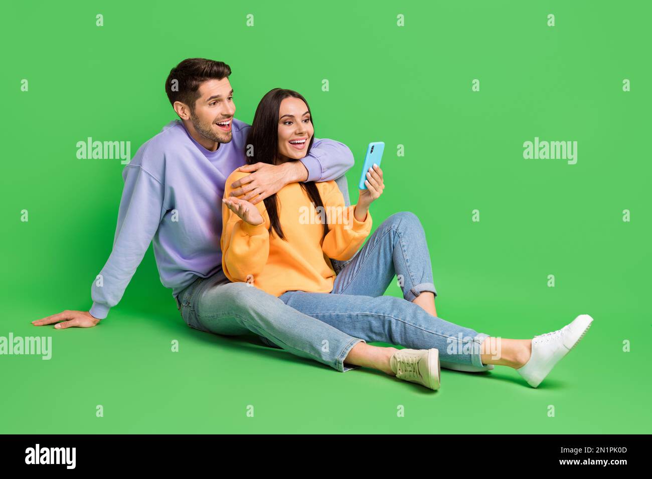 Full body portrait of two excited funny people sit floor cuddle speak ...