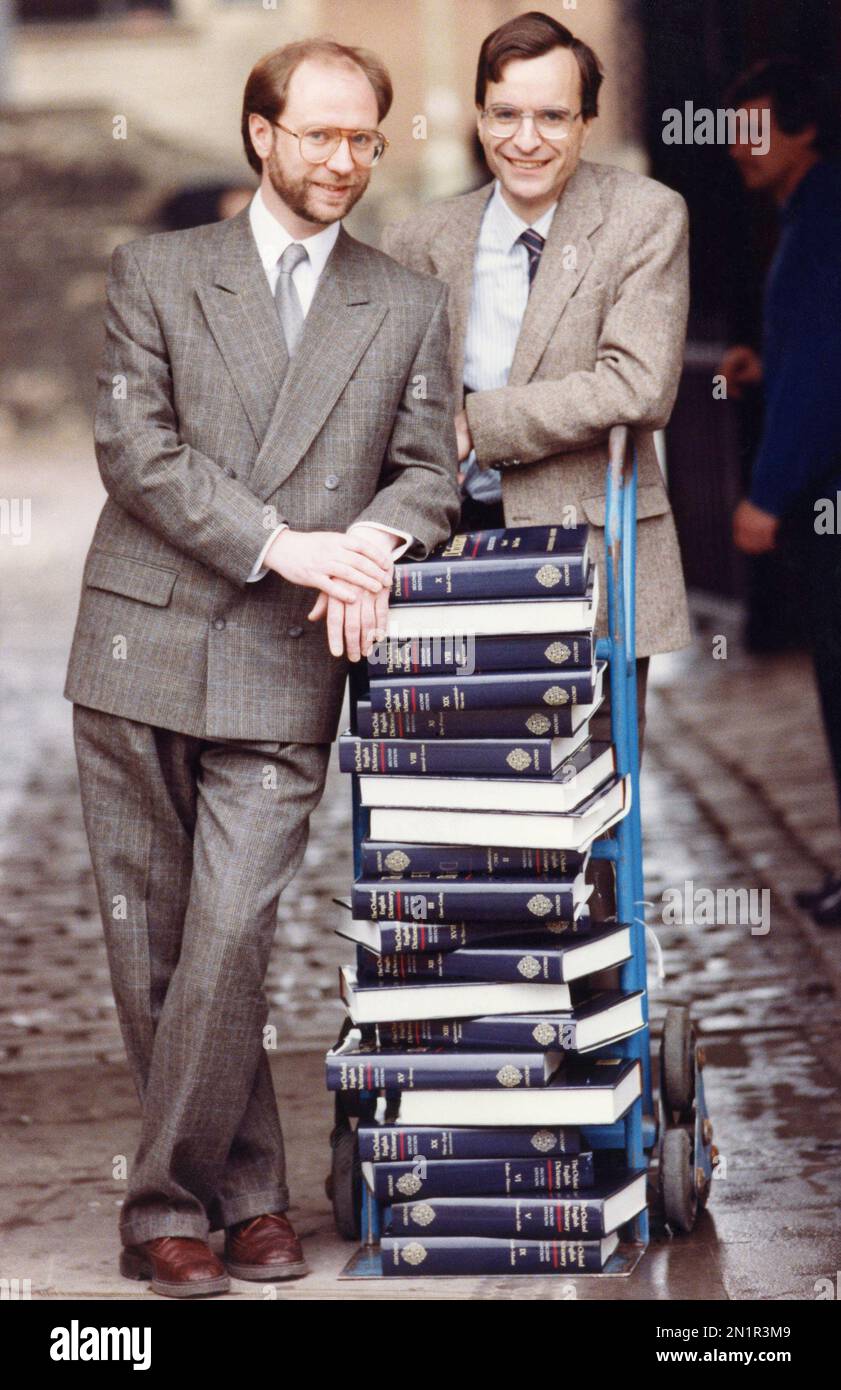 John Simpson, left, and Edmund Weiner stand with a stack of books - a ...