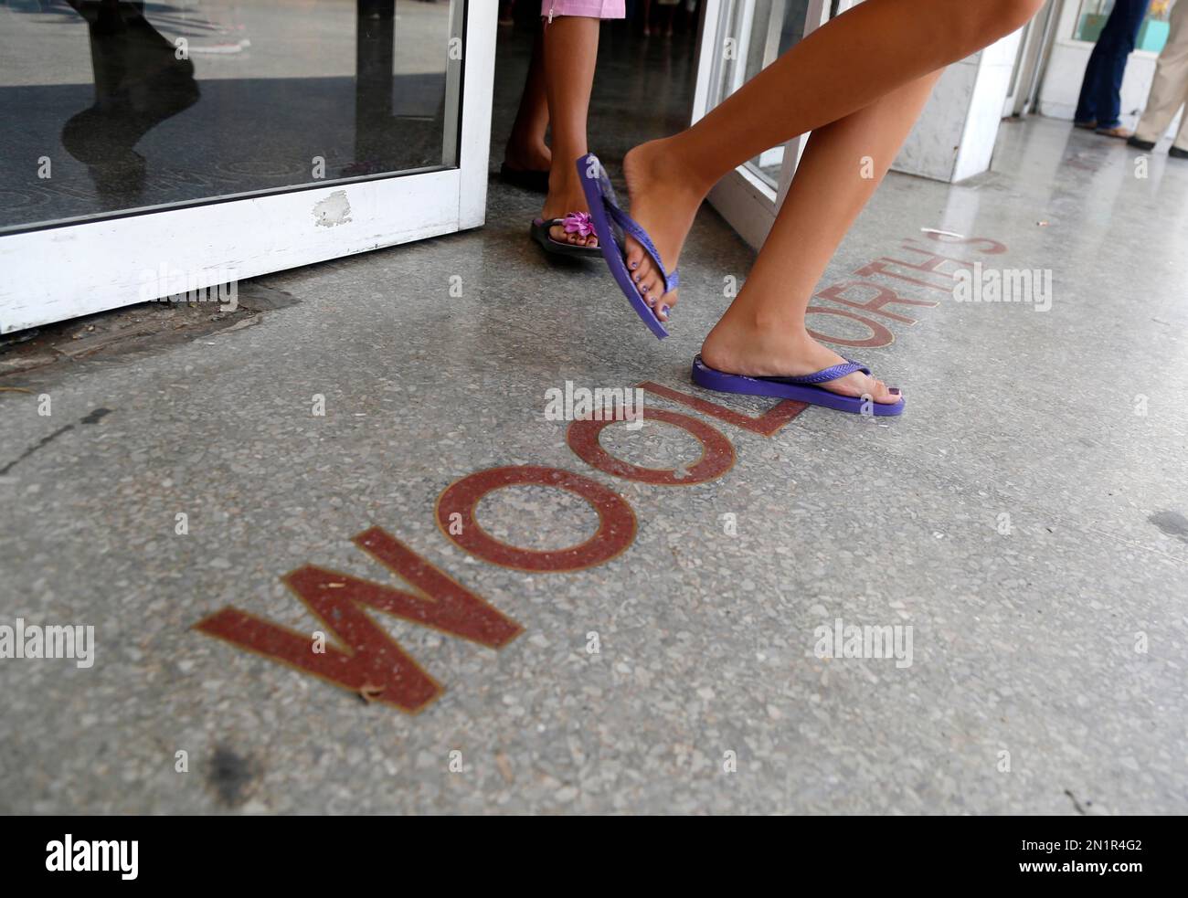 People walk over a Woolworth's the sign on the floor of the entrance of ...