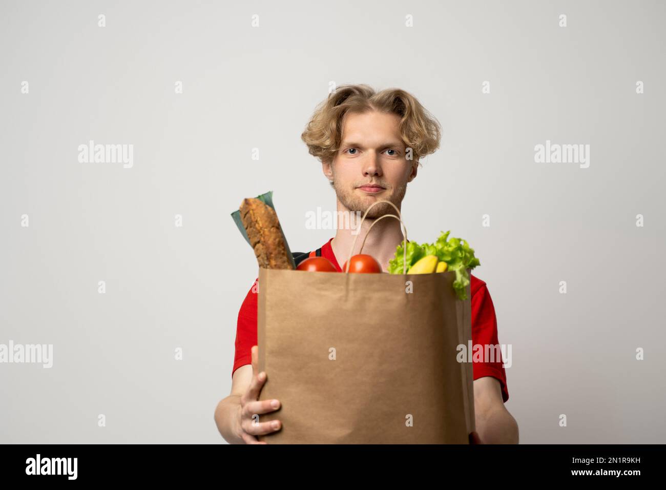 Food delivery service concept. Handsome delivery man, courier carrying ...