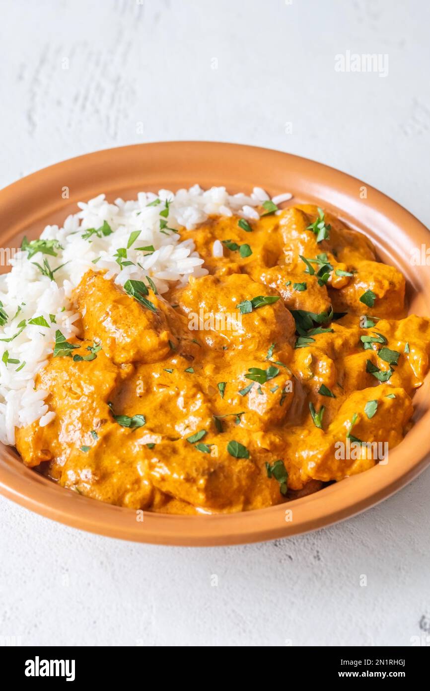 Bowl of Chicken tikka masala garnished with white rice Stock Photo - Alamy