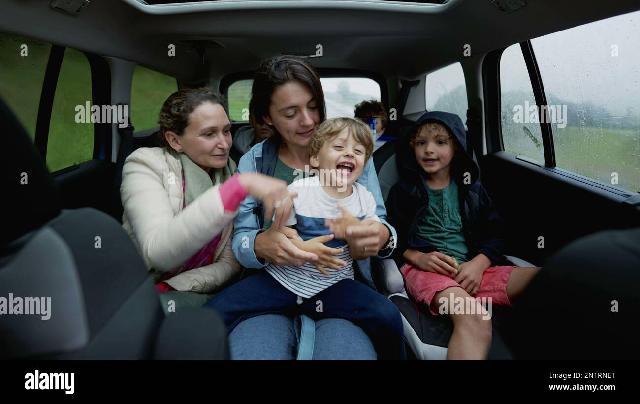 Happy family in car backseat traveling on road. Kids and women travel ...