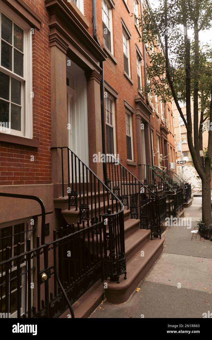 brick building with white windows and entrances with stairs and metal ...