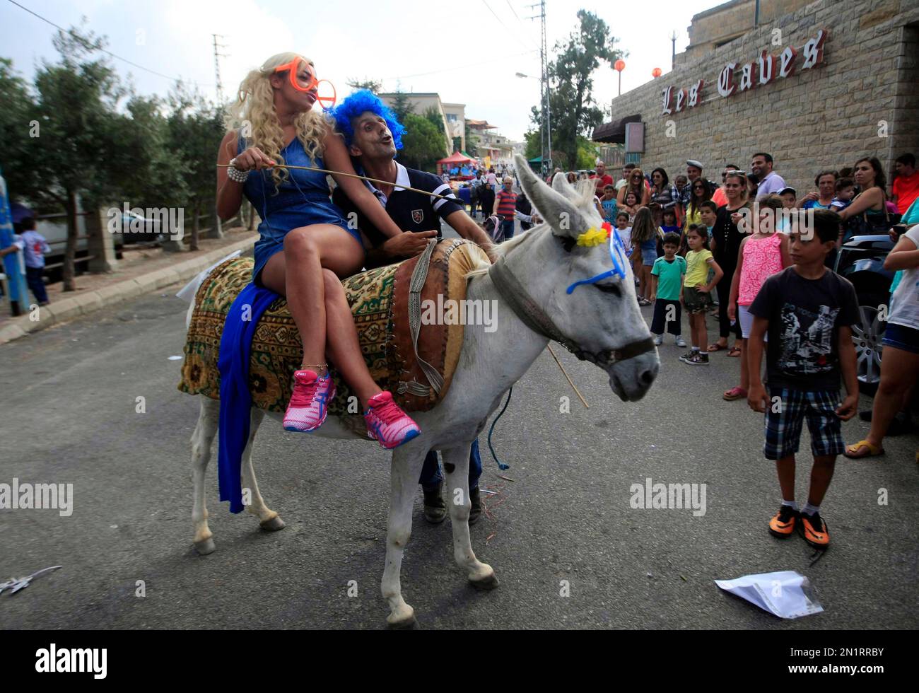 A Lebanese woman rides a donkey and poses for a photograph during an ...