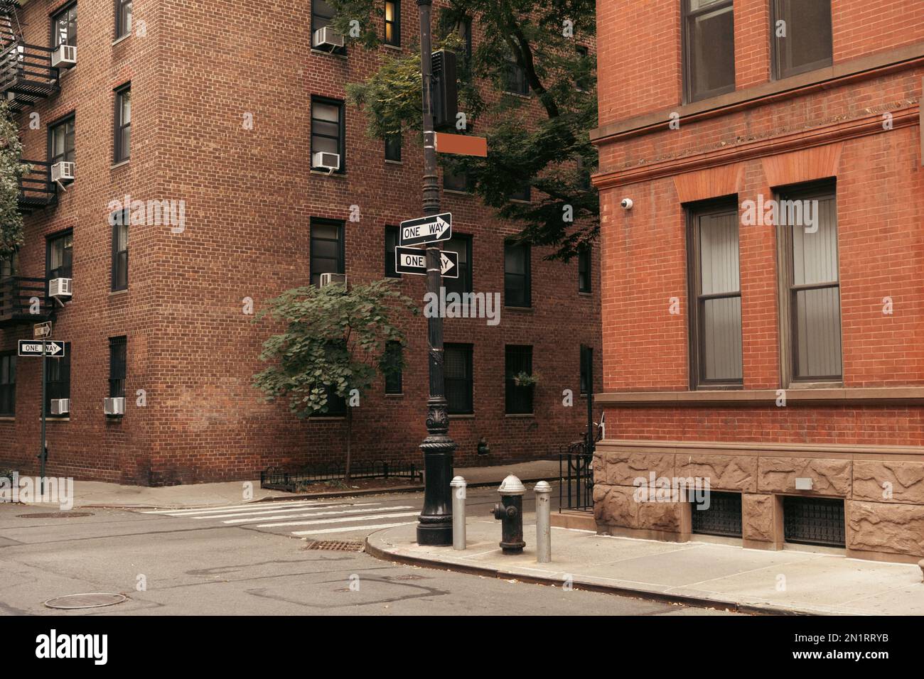 Pointers between brick buildings on street in New York City,stock image ...