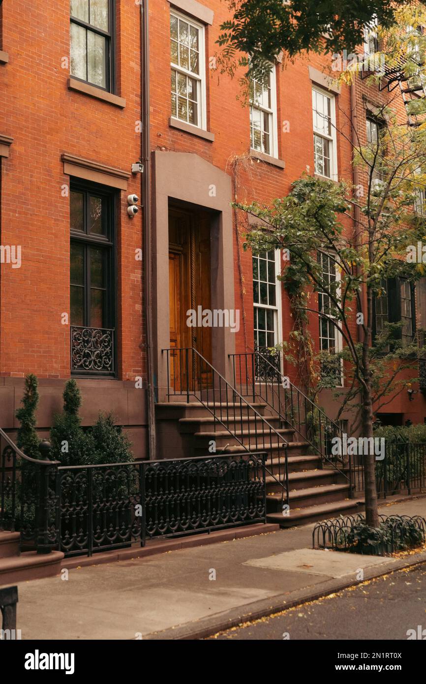 Trees and fence near brick building on street of brooklyn heights in ...