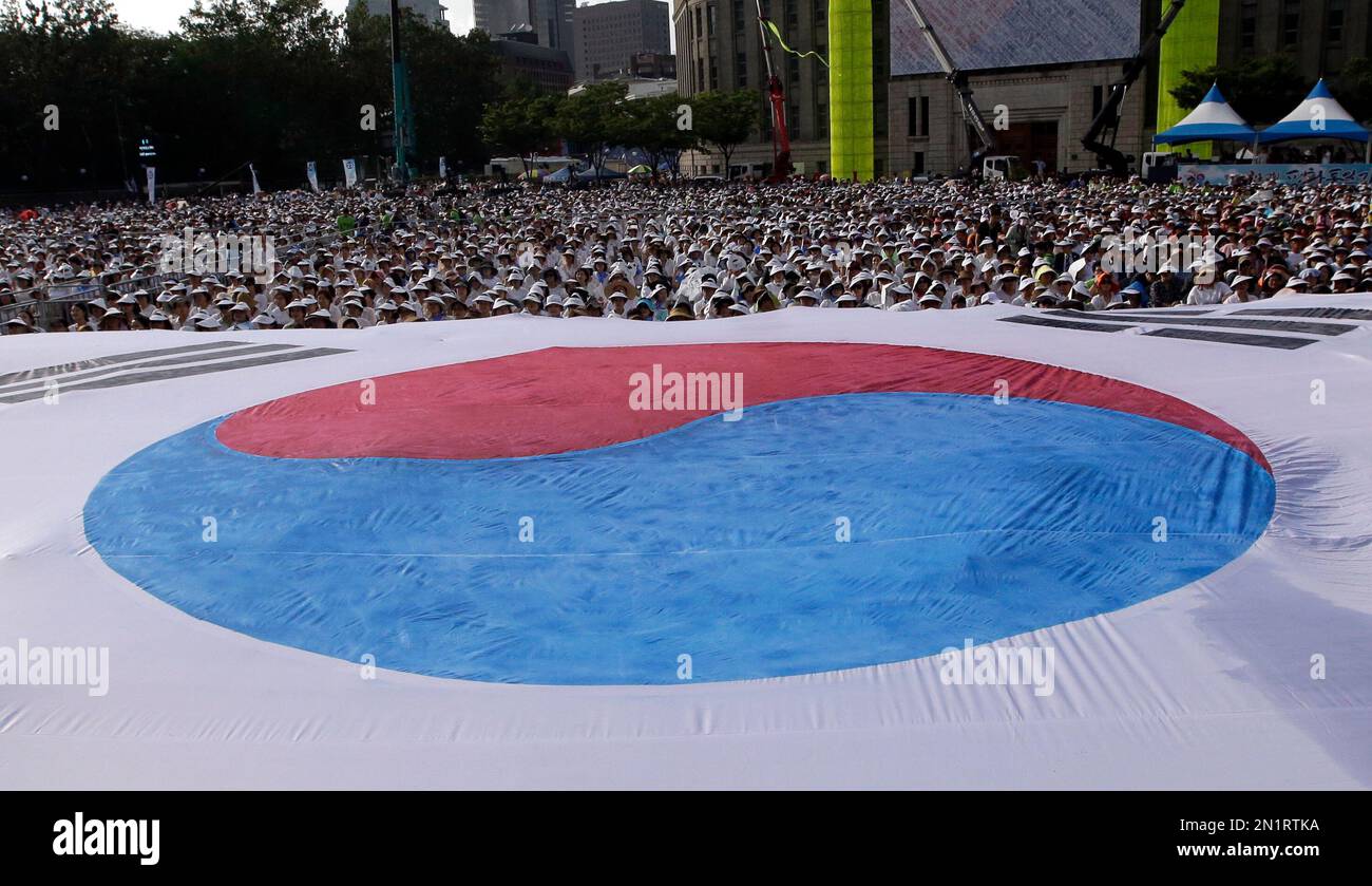 South Korean Christians carry a huge national flag during a service to ...