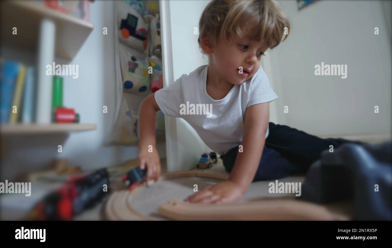 Child playing in room. One small kid plays by himself with toys. Little ...