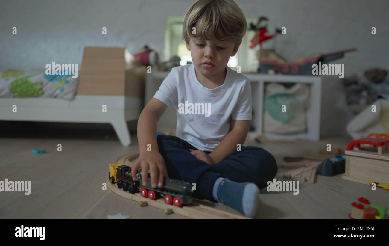 Child playing in room. One small kid plays by himself with toys. Little ...