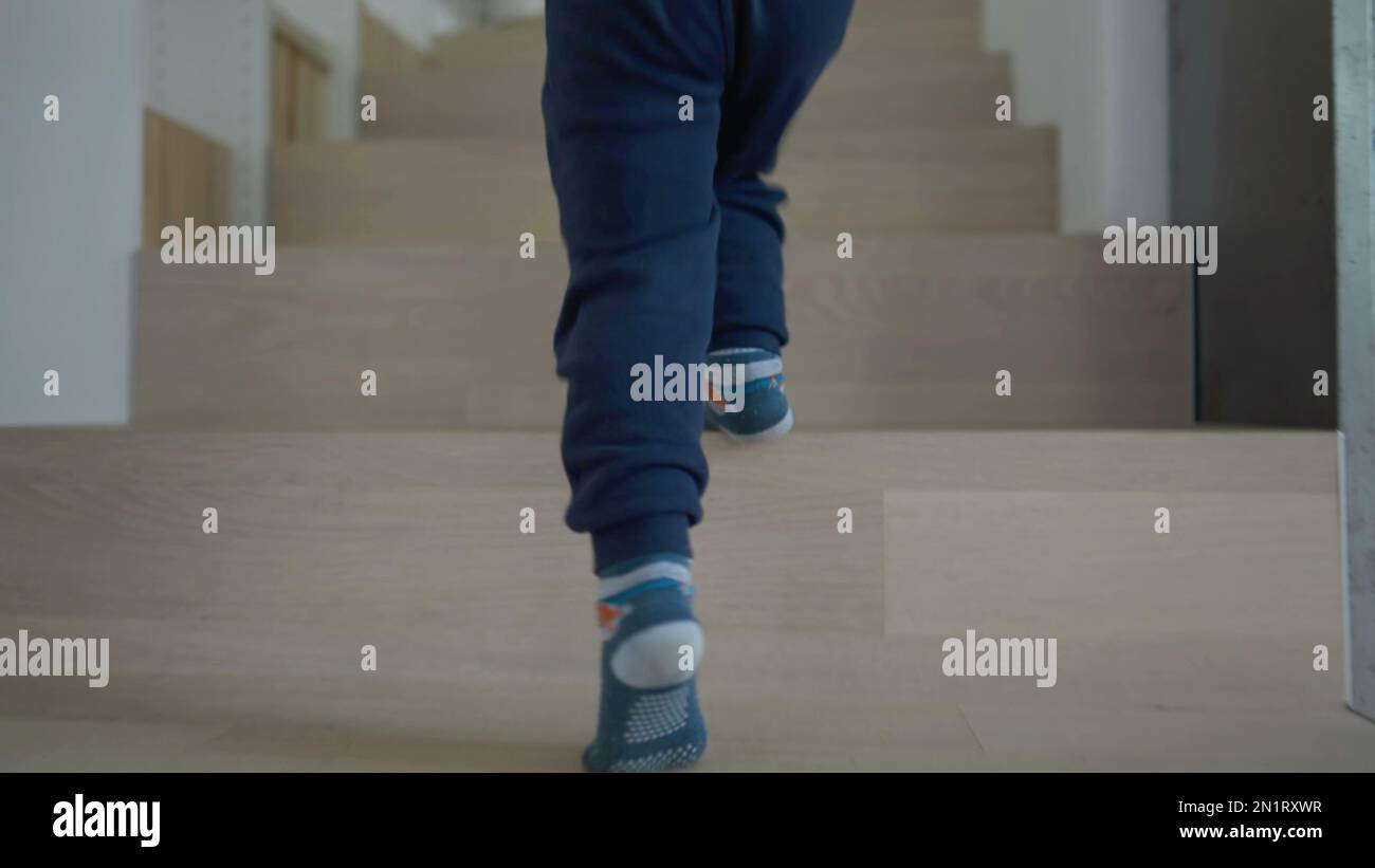 Child feet walking up the stairs. Kid legs climbing staircases at home ...