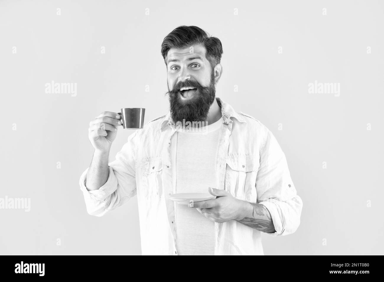 Happy guy drinking coffee from cup holding saucer yellow background ...