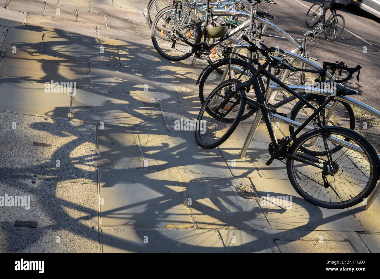 Bikes and their shadows are seen on the pavement where more streets are ...