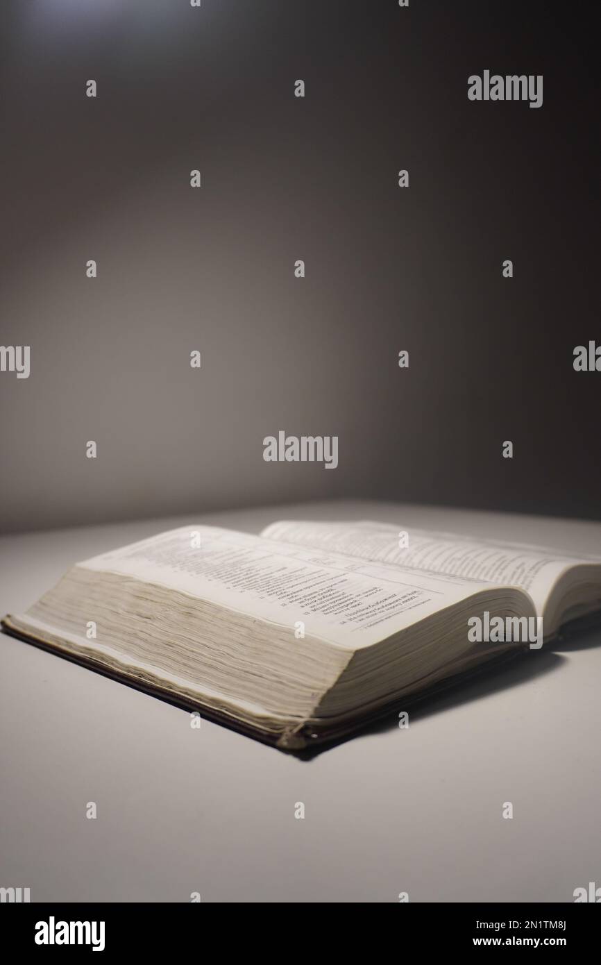 A vertical shot of the open Bible on the white table Stock Photo - Alamy