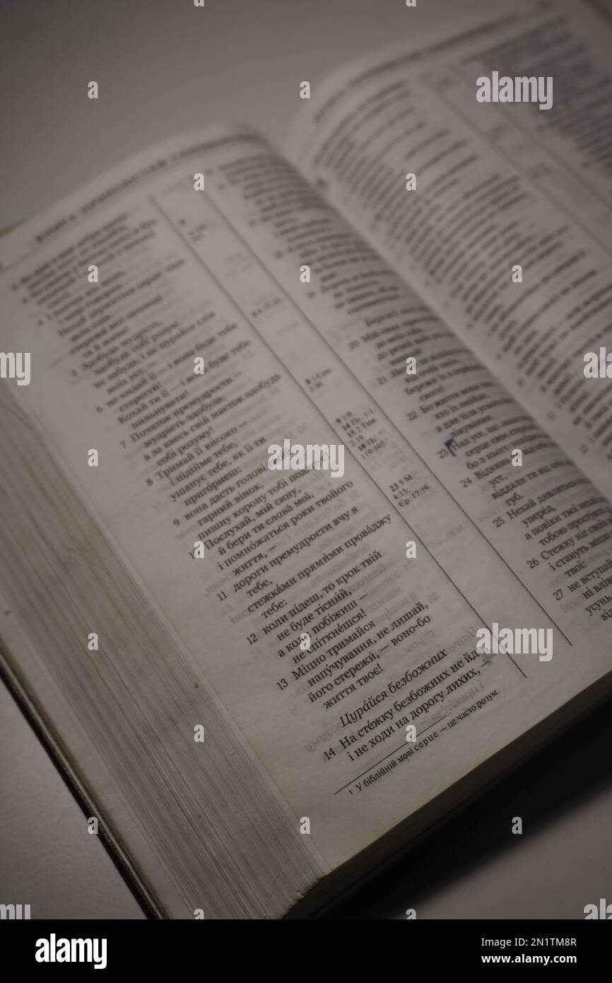 A vertical shot of the open Bible on the white table Stock Photo - Alamy