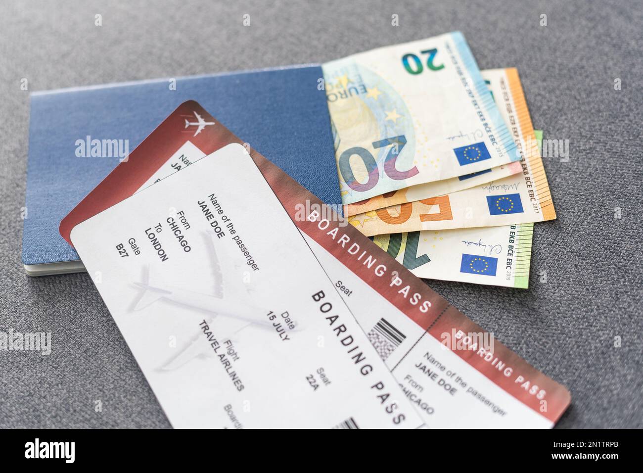 Two blue passports, green boarding pass, flight tickets gray background ...