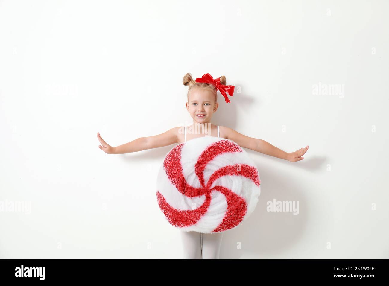 Cute little girl dressed as candy on white background. Christmas suit ...