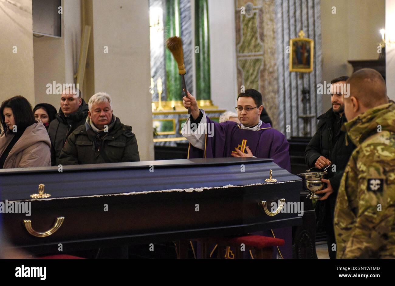 KYIV, UKRAINE - FEBRUARY 6, 2023 - A priest sprinkles the coffin of ...