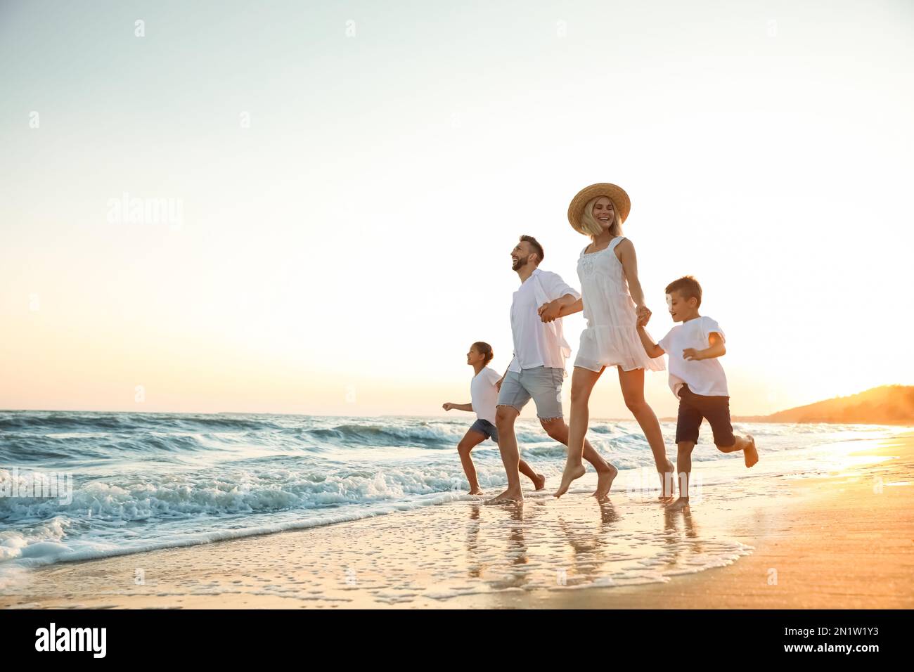 Happy family running on the beach hi-res stock photography and images ...