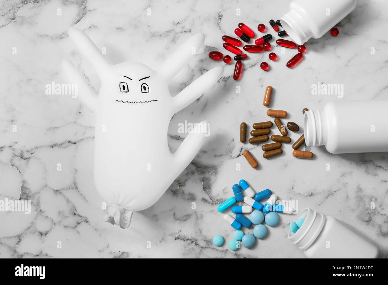 Glove monster and different pills on white marble table, flat lay ...