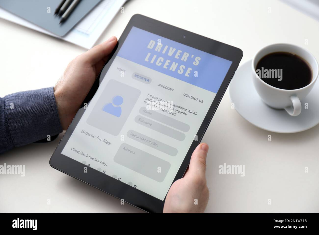 Man holding tablet with driver's license application form at white table, closeup Stock Photo ...