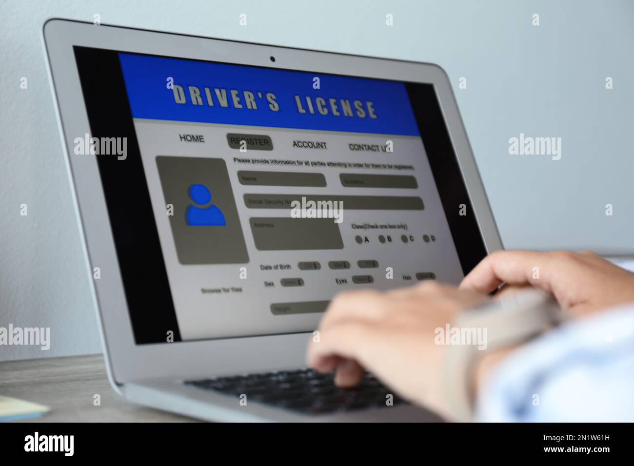 Woman using laptop to fill driver's license application form at table, closeup Stock Photo - Alamy