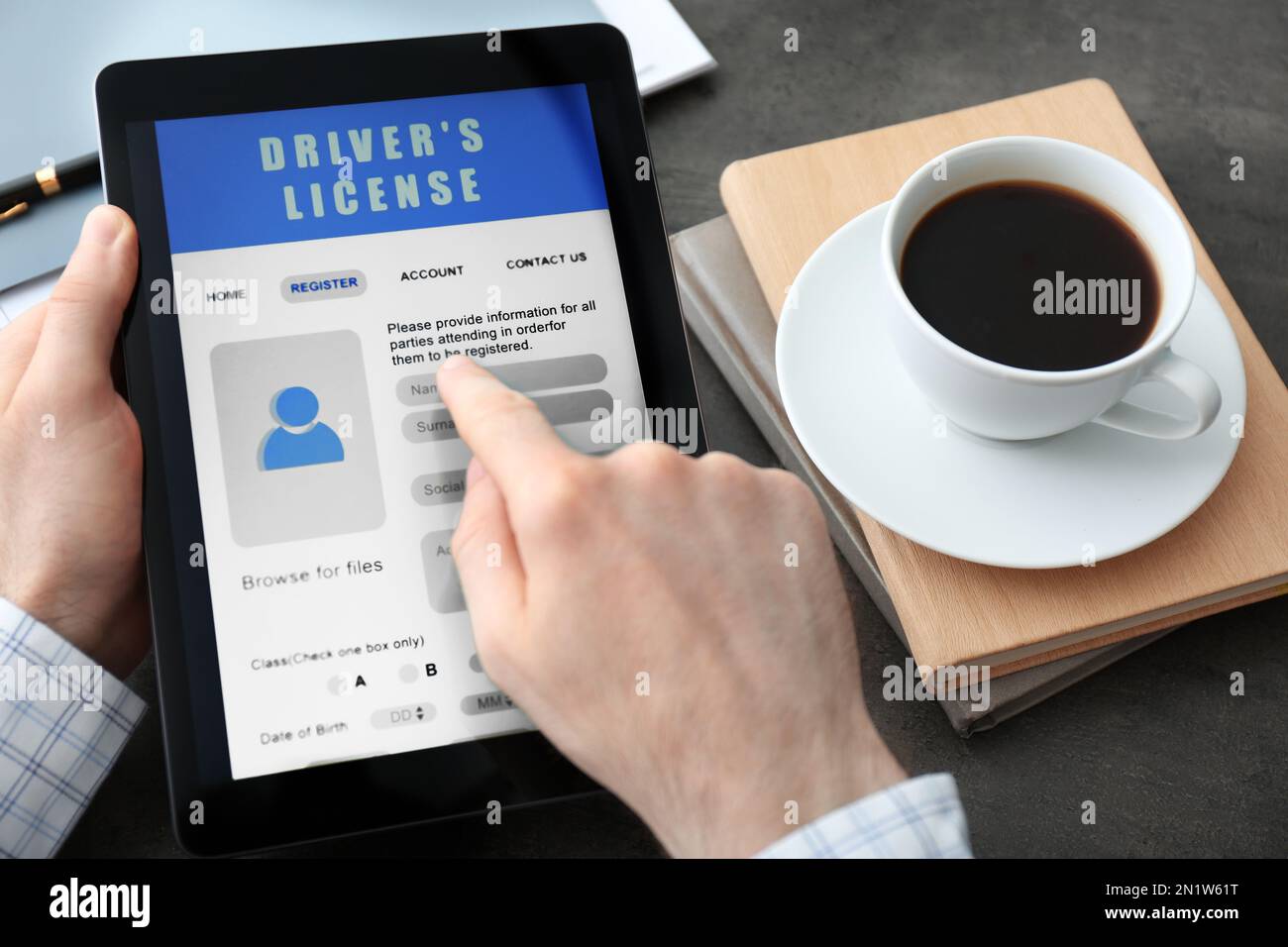 Man using tablet to fill driver's license application form at grey table, closeup Stock Photo ...