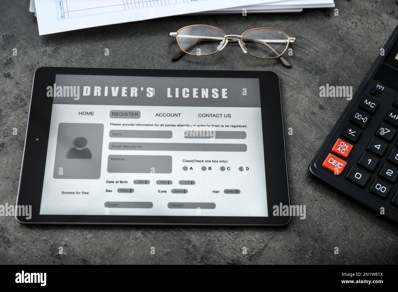 Tablet with driver's license application form, glasses and calculator on grey table Stock Photo ...