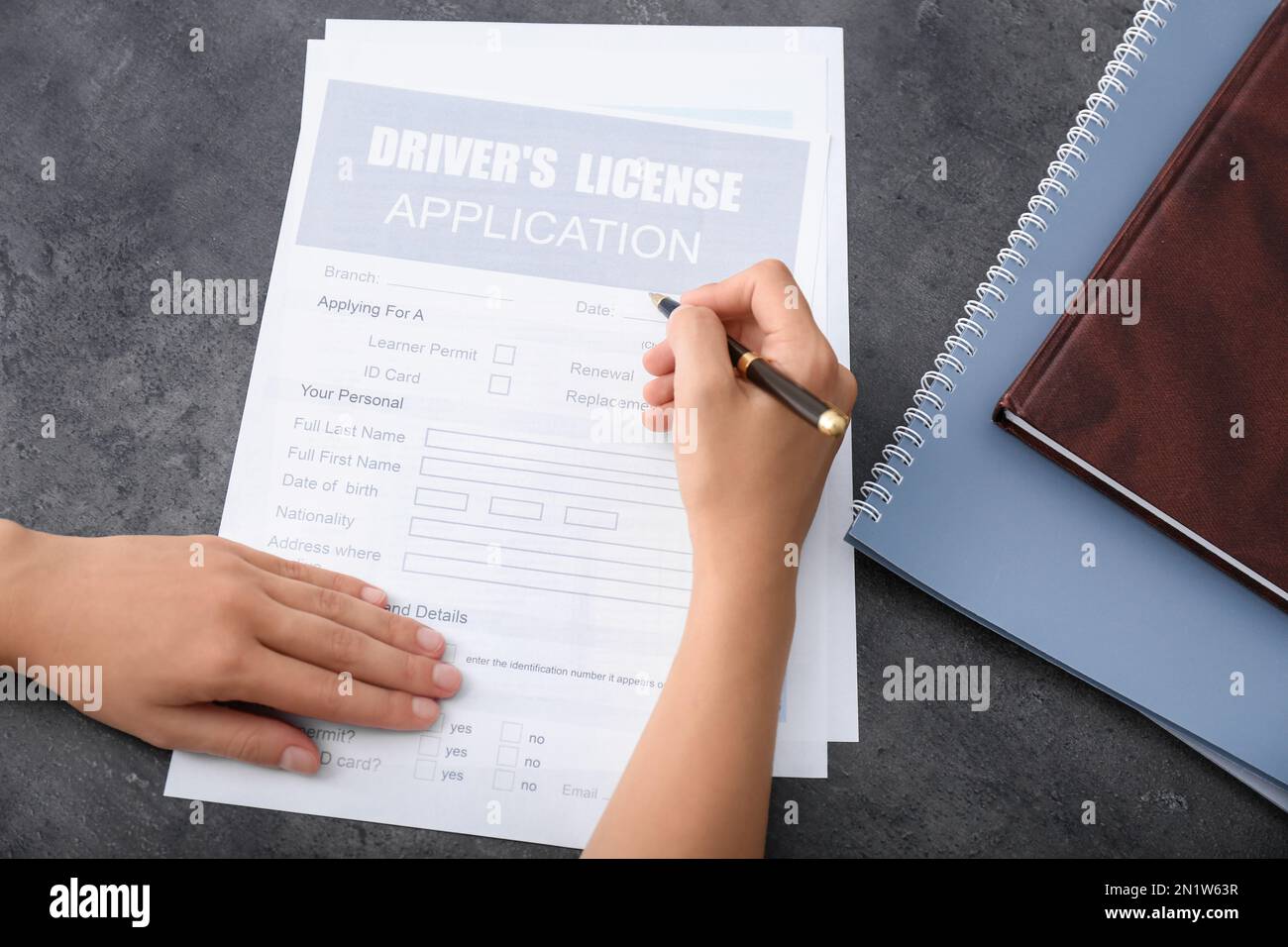 Man filling in driver's license application form at grey table, top view Stock Photo - Alamy