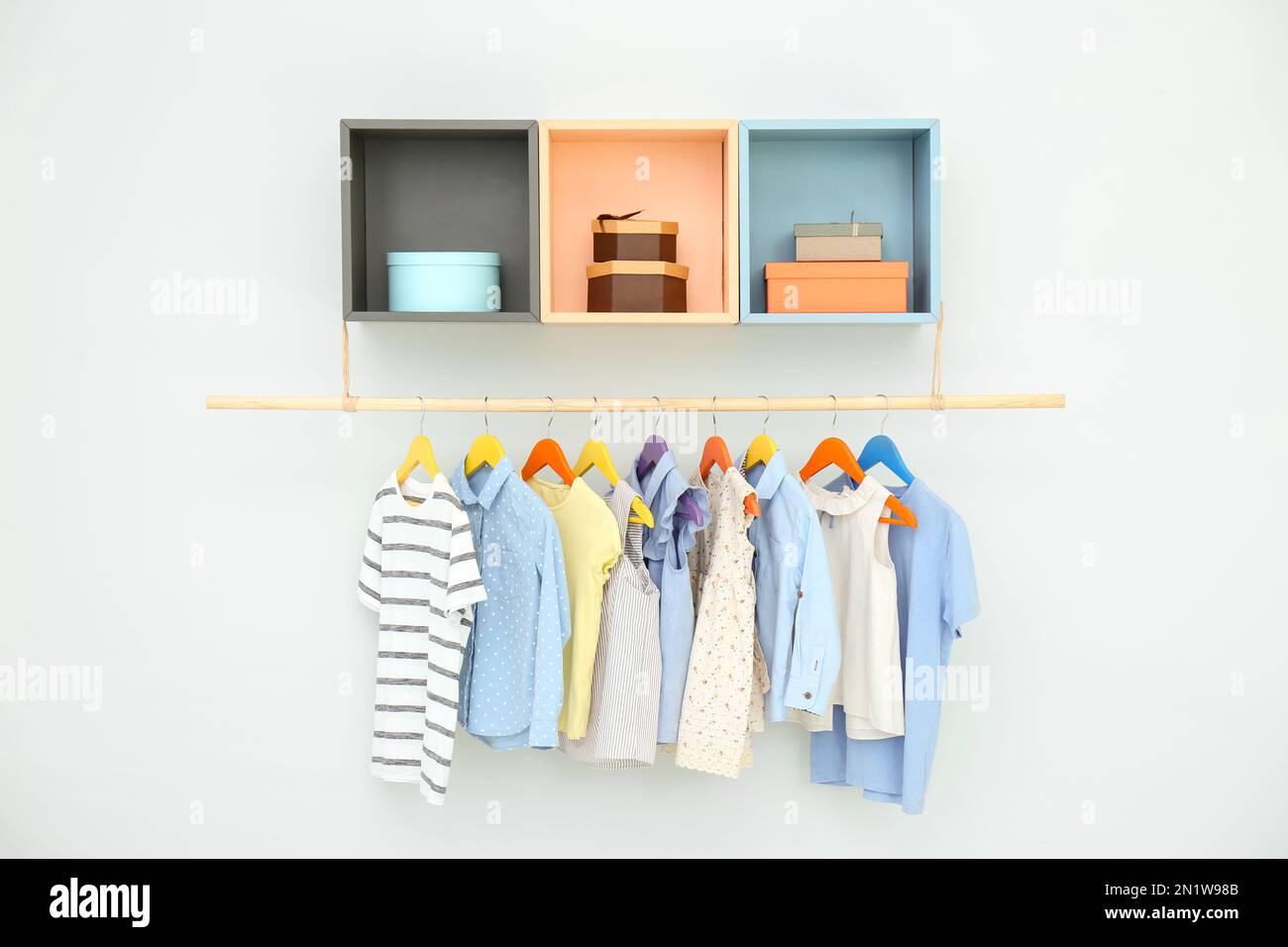 Rack with different clothes on light background Stock Photo - Alamy