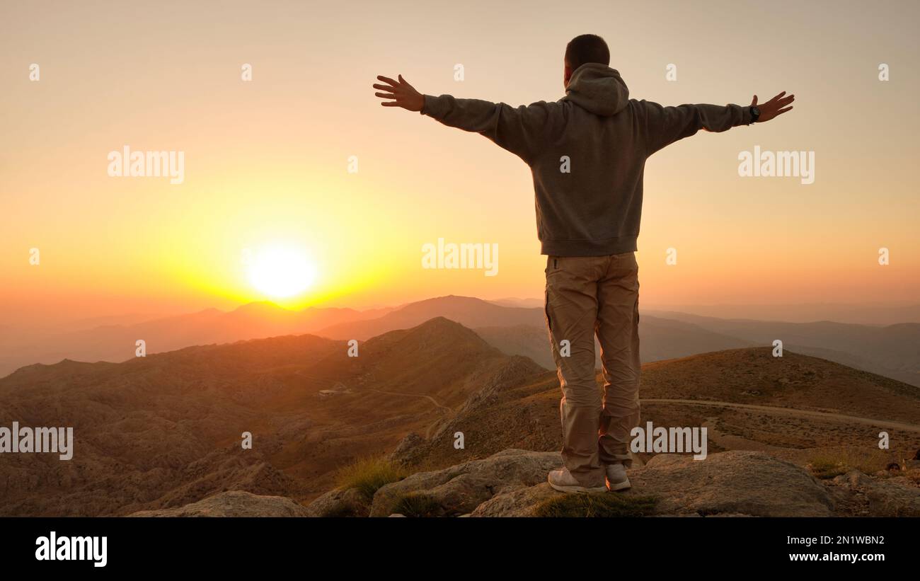 Man meets the dawn at the top of a mountain Stock Photo - Alamy