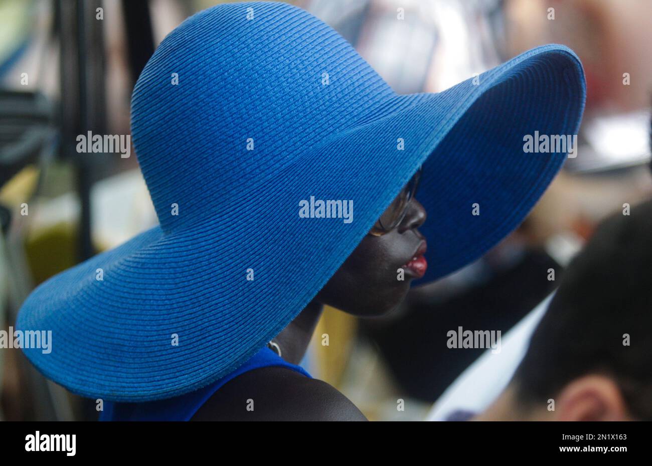 A woman waits for the unveiling of a 24' x 10' tapestry depicting the ...
