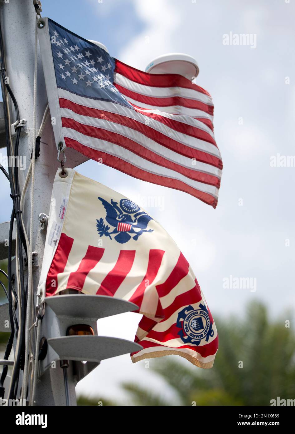 The U.S. Coast Guard ensign flies below the U.S. flag aboard a Coast ...