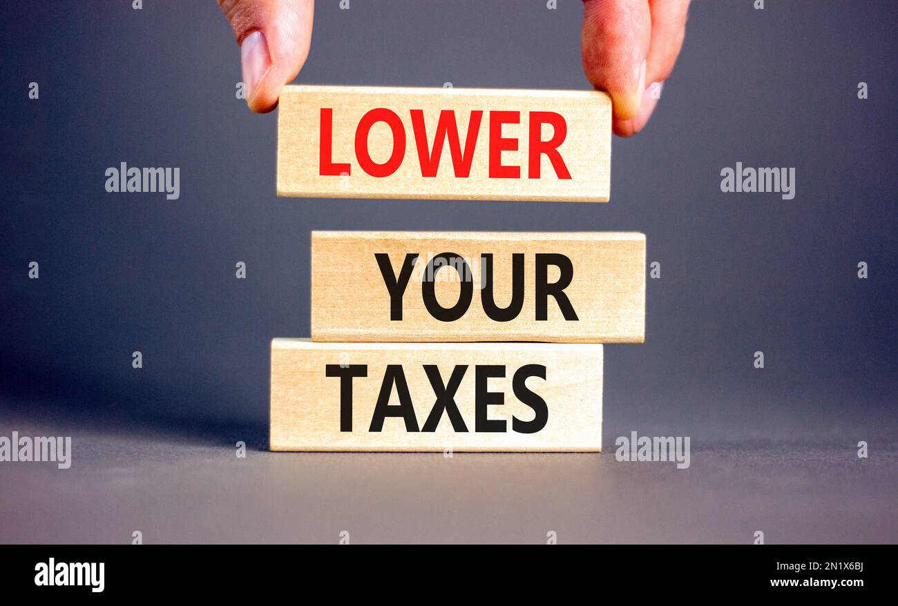 Lower your taxes symbol. Concept words Lower your taxes on wooden ...