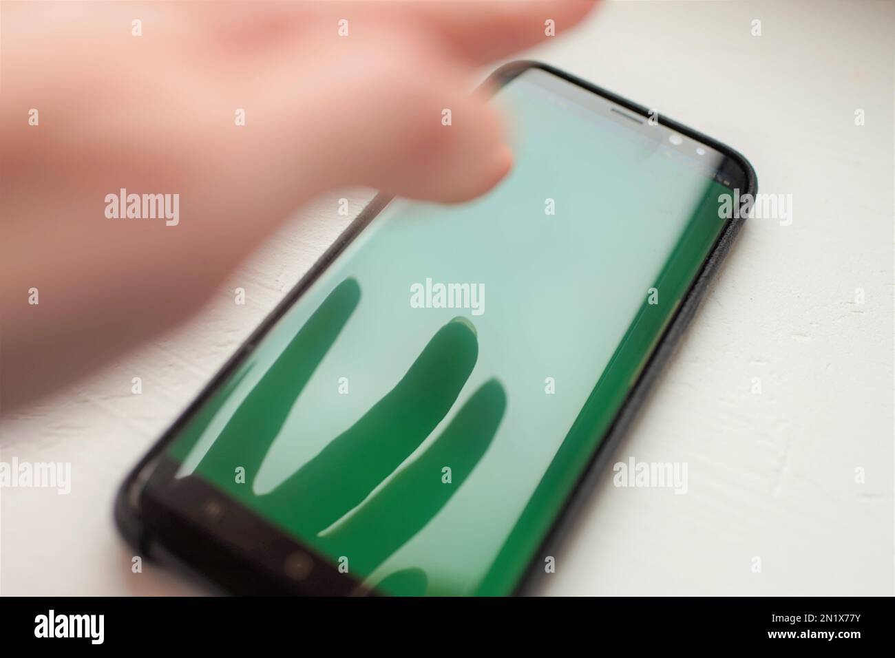Female hand under black smartphone with green screen and shadow fingers ...