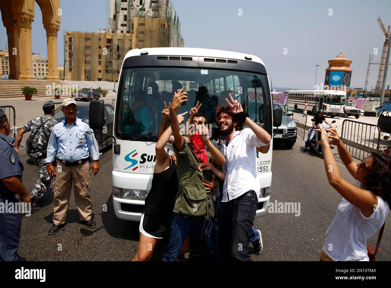 Lebanese protesters take a selfie in front of a bus from the waste ...