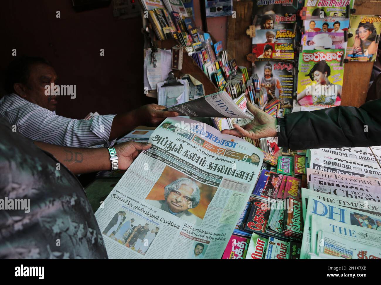 An Indian vendor sells newspapers with the headlines of former ...