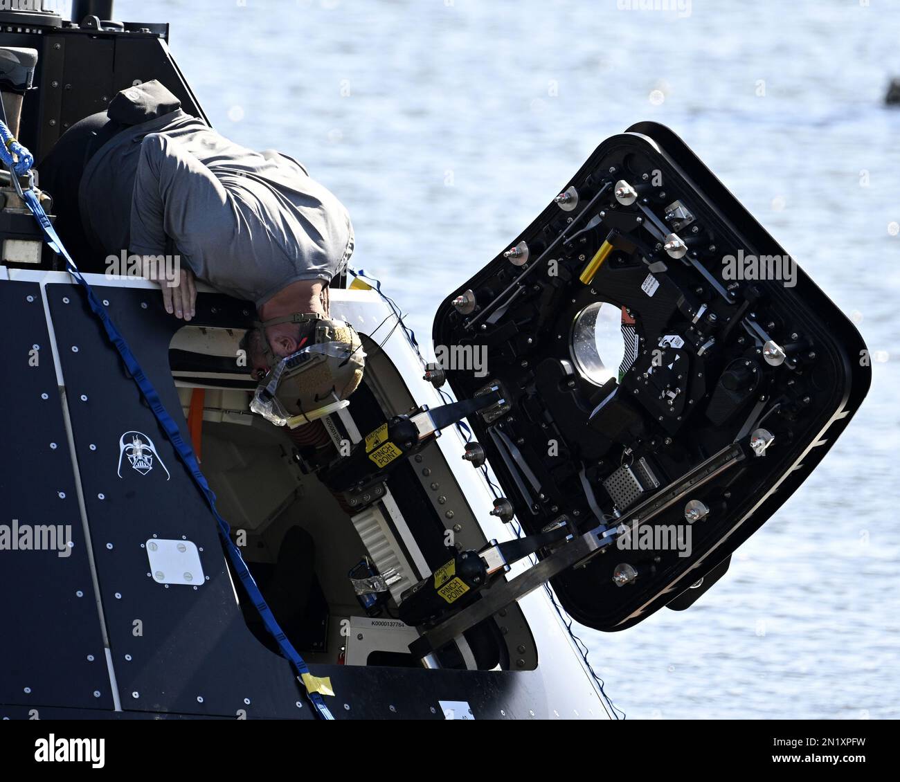 A diver peers into an open hatch as NASA and Department of Defense ...