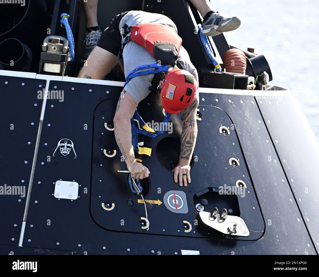 A member leans over to open the hatch as NASA and Department of Defense ...