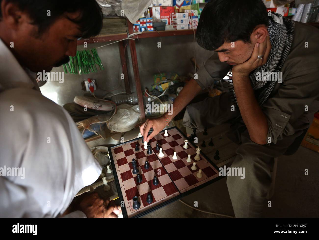 Afghan men play a game of chess in a shop on the outskirts of Kabul ...