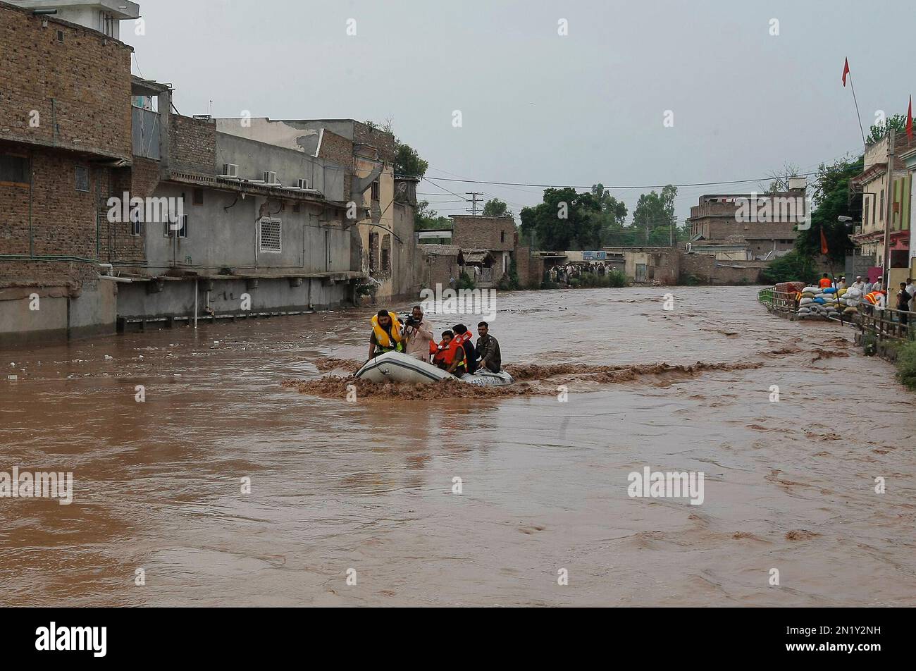 Pakistani volunteers evacuate marooned people after heavy rains in a ...