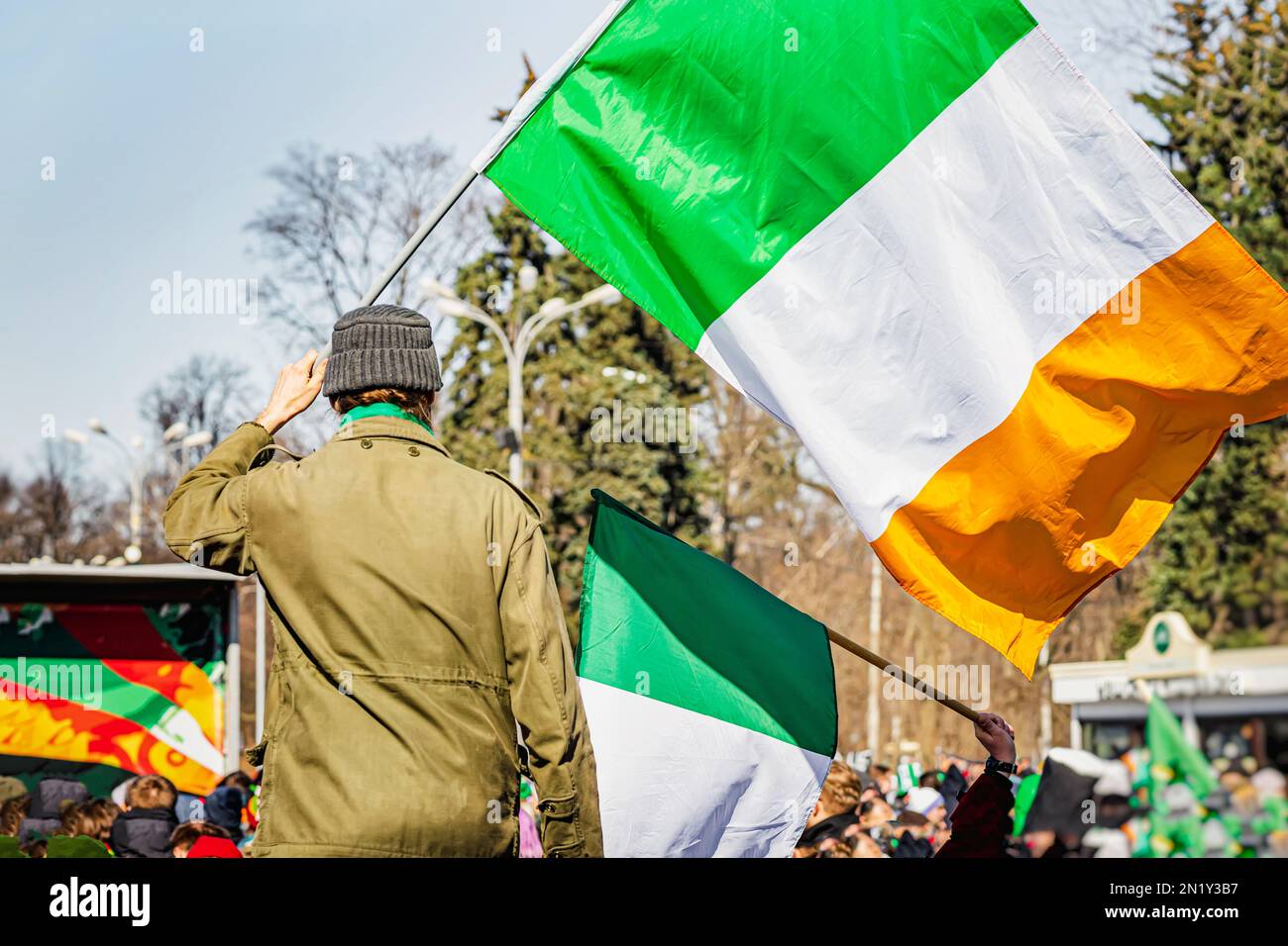 Back view of man with National Flag of Ireland on background of crowd ...