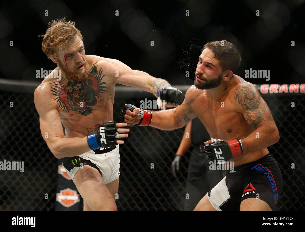 Conor McGregor, left, fights Chad Mendes during their interim ...